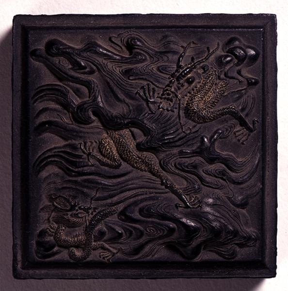 Ink-cake in seal form with a domed knop moulded in dramatic relief with ...
