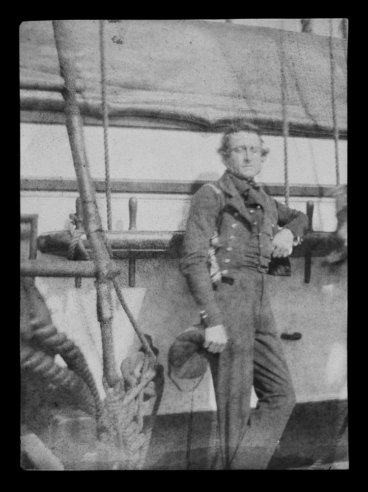 An unidentified naval officer standing by the belaying pin rail on the ...