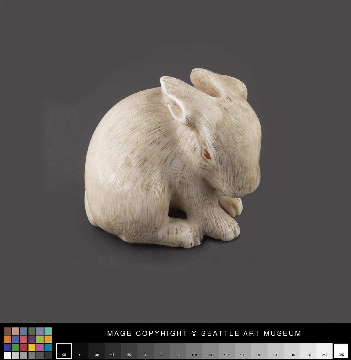 Netsuke modeled as a hare with amber eyes by Japanese School