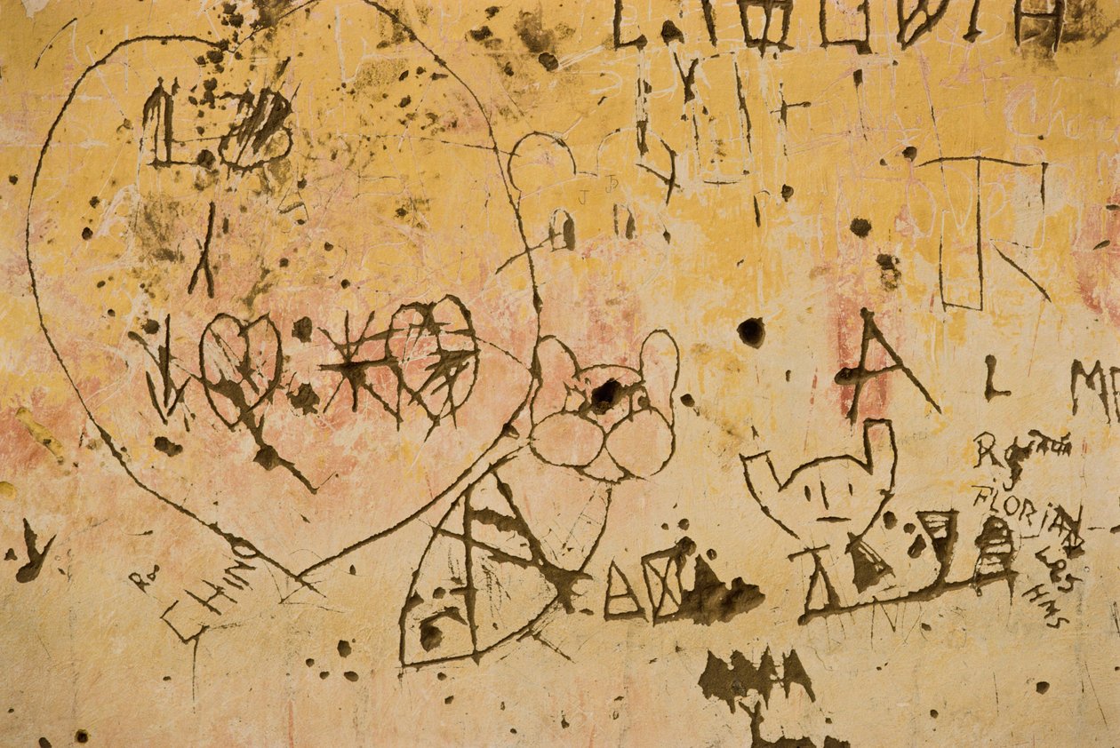 Graffiti Etched into an Old Exterior Plaster Wall